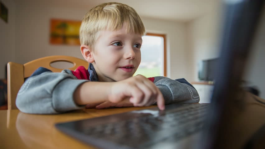 Kid On Computer Carefully Using Touch Pad With Finger. Low Angle Wide ...